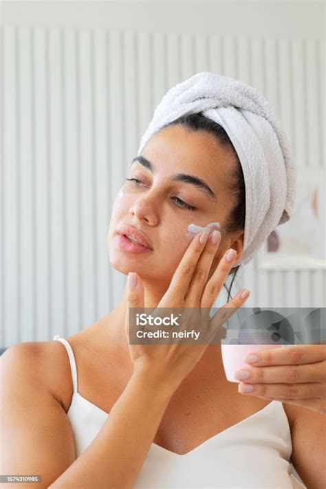 매력적인 갈색 머리 여자 와 수건 감싸에 그녀의 머리 적용 보습 얼굴 크림 25 29세에 대한 스톡 사진 및 기타 이미지 25 29세 가정 생활 가정의 방 Istock