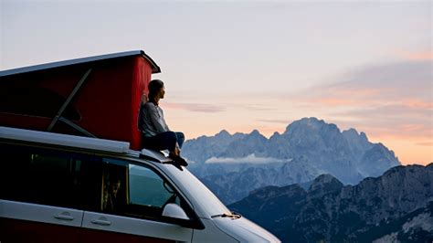 해질녘 캠핑카의 옥상 텐트 밖에 앉아 목가적인 산맥을 바라보는 여성 관광객의 전체 길이 Mangart에 대한 스톡 사진 및 기타 이미지 Mangart 경관 경외감