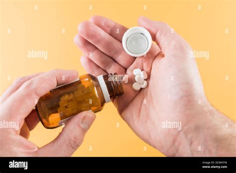 Close Up Of Hands Dispensing Tablets From Pill Bottle Medication