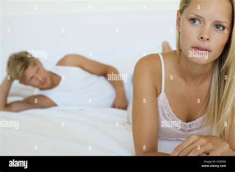 Woman Relaxing On Bed Man Lying In Background Stock Photo Alamy