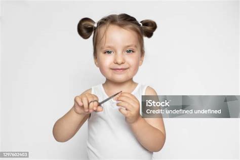 두 포니 테일금발 머리를 가진 어린 소녀 고립 된 스튜디오 흰색 배경에 행복한 미소로 카메라에 포즈 가위를 사용하여 매니큐어 절차를 만드는 동안 가위에 대한 스톡 사진 및