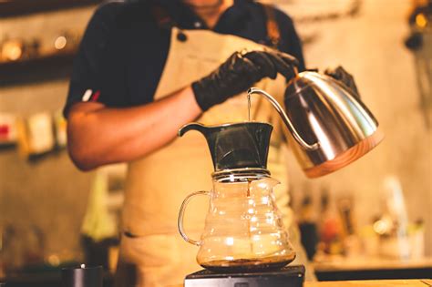 드립 커피 필터 스타일 컨셉의 빈티지 슬로우 바 카페 뜨거운 음료를 만드는 바리스타 뜨거운 물과 아라비카 커피 원두 가루를 컵에