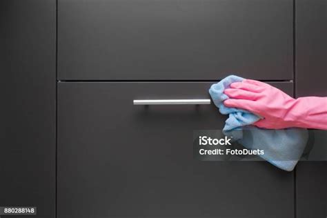 직원 마이크로 섬유 피복 부엌에서 찬 장 표면을 닦아 고무 보호 장갑에 손을 이른 봄 또는 일반 정리입니다 상업적인 청소 회사 개념입니다 가구에 대한 스톡 사진 및 기타