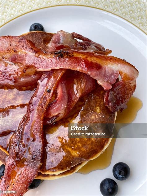 푹신한 미국식 팬케이크 구운 베이컨 러셔 블루베리가 접시에 떨어지는 메이플 시럽을 뿌린 신선한 스택의 전체 프레임 이미지 높은