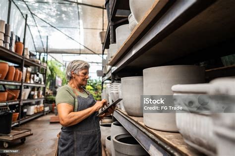 가든 센터에서 디지털 태블릿을 사용하여 재고를 점검하는 고위 영업 사원 60 64세에 대한 스톡 사진 및 기타 이미지 60 64세 기업가 꽃 시장 Istock