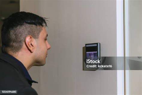 얼굴 스캐너를 사용하여 사무실 건물의 문을 여는 남자 출입 통제 얼굴 인식 시스템 보안 시스템을 위한 생체 인식 출입 제어 장치 생체 인식 출입 제어 장치 35 39세에