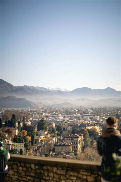 도시가 내려다 보이는 벽에 앉아있는 사람 사진 Unsplash의 무료 초상 이미지