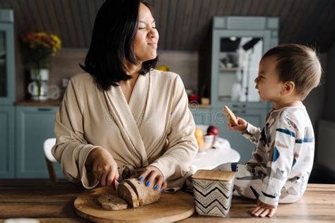 Happy Mother Making Fun With Her Son While Cutting Bread Stock Image