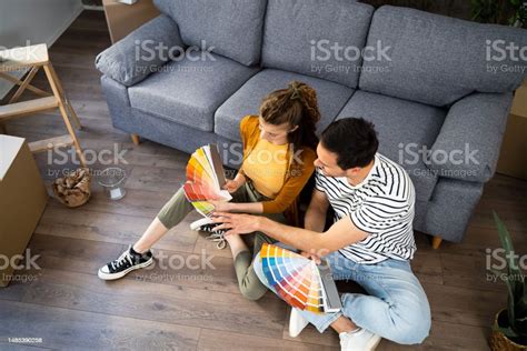 커플은 바닥에 앉아 색상 견본을 보면서 새 아파트의 컬러 페인트를 선택한다 25 29세에 대한 스톡 사진 및 기타 이미지 25 29세 2명 가정 생활 Istock