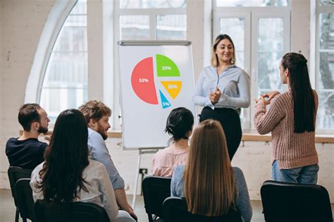워크숍에서 홀에서 발표하는 여성 연사 청중 또는 컨퍼런스 홀 인식되지 않는 참가자의 후방 보기 20 24세에 대한 스톡 사진 및