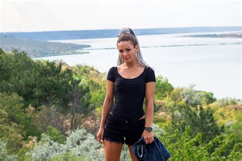 검은 옷을 입은 아프로 브레이드를 입은 아름다운 검게 그을린 백인 여성이 호수 근처 절벽에 서 있습니다 땋은 머리에 대한 스톡 사진 및 기타 이미지 Istock