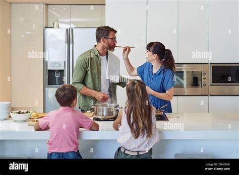 Theyre All Eager To Dig In To Moms Cooking A Mother Giving Her Husband A Taste Of The Meal That