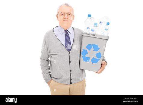 Senior Man Holding A Recycle Bin Full Of Plastic Bottles Isolated On White Background Stock