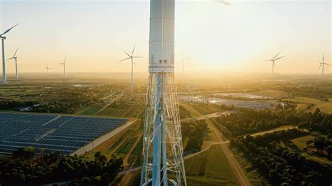 Massive Solar Tower Illuminated By Sunlight With Wind Turbines Spinning