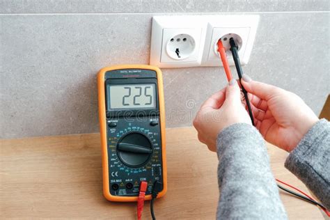 Woman With A Multimeter Check The Voltage Of The Electrical Network Woman Checking Voltage In