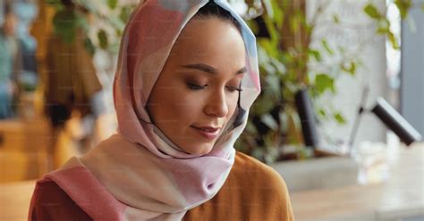 히잡을 쓴 소녀 아름 다운 무슬림 여자 초상화입니다 카페에 앉아 태블릿에서 일하는 여성 화면을보고 읽는 모델 사진 Unsplash의 식당 이미지