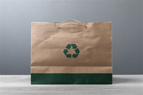 재활용 기호가 있는 갈색 종이 봉지가 테이블 위에 놓여 있습니다 이 이미지는 지속 가능성과 친환경 관행의 개념을 강조하여 재료의 재사용과 재활용을 장려합니다 0에 대한 스톡