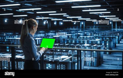 Female It Specialist Using Chroma Key Laptop In Data Center Big Server Farm Cloud Computing