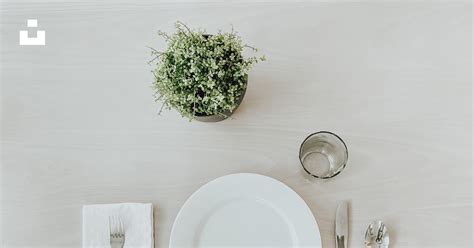 흰색 테이블에 스테인레스 스틸 포크와 빵 칼 옆에 흰색 세라믹 접시 사진 Unsplash의 무료 식탁 이미지