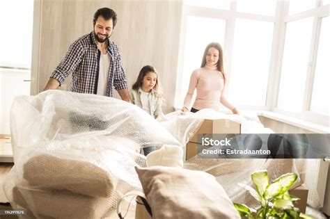 아름 답 고 친절 한 가족은 그들의 물건을 풀고 있습니다 그들은 상자의 표지를 벗어 버리고 있습니다 거기에 많은 물건이 있습니다