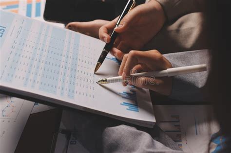 Group Of Confident Business People Point To Graphs And Charts To