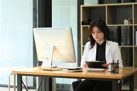 Concentrated Young Businesswoman Analyzing Statistics Data Documents At