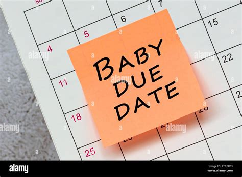 Baby Due Date Written On A Orange Paper Sticky Note And Stuck To A Calendar Background Reminder