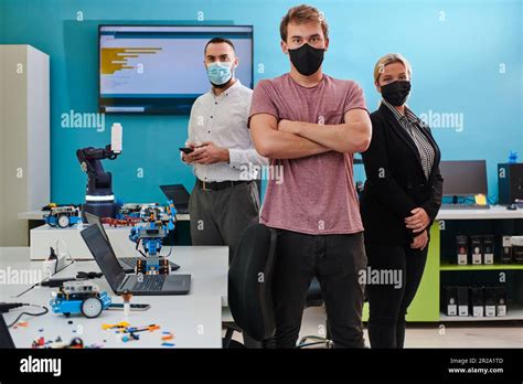 A Group Of Colleagues Working Together In A Robotics Laboratory Focusing On The Intricate