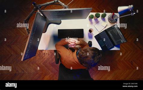 Aerial Shot Of Computer Scientist Listening Music While Writing Lines Of Code During Remote Job