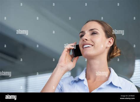 Calling A Client An Attractive Young Businesswoman Using Her Cellphone