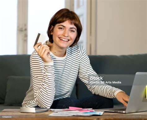 신용 카드와 노트북 지불 청구서 요금 모기지 집에서 소파에 편안한 느낌을 가진 행복 한 매력적인 여자 중소 기업 성공 가정 재정 전자 뱅킹 전자 상거래 개념 거실에 대한