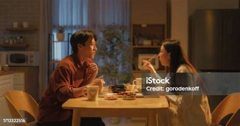 집에서 집에서 맛있는 음식을 먹고 즐거운 대화를 나누는 젊은 한국인 커플 아시아인 남자친구와 여자친구는 함께 시간을 보내고 익힌