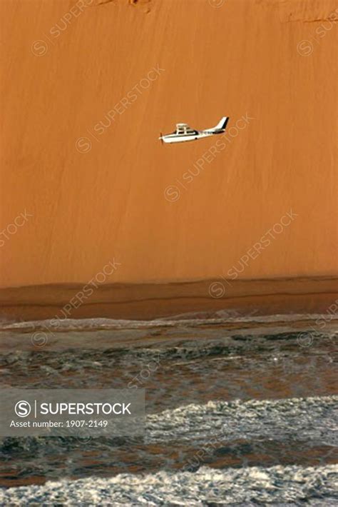 on the skeleton coast a small cessna is flying between the ocean and