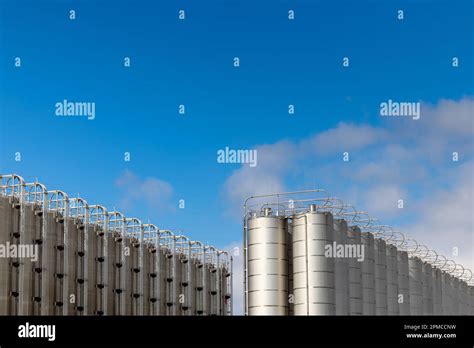 Stainless Steel Silos Against The Blue Sky Warehouses For Storage Of Plastics And Bulk Grains