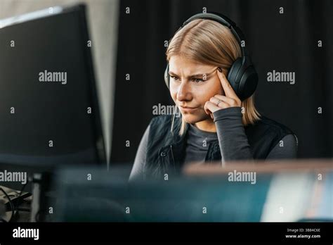 Concentrated Female Computer Programmer Wearing Wireless Headphones