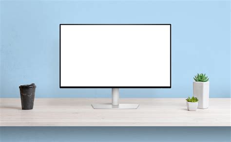 웹 페이지 프레젠테이션을 위해 격리된 화면이 있는 작업 장의 컴퓨터 디스플레이입니다 커피와 식물 옆에 배경의 파란색 벽 0명에 대한 스톡 사진 및 기타 이미지 Istock