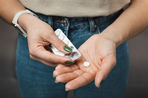 젊은 여자가 손에 흰 알약을 들고 물집 팩에서 약을 먹고 클로즈업 보기 건강관리와 의술에 대한 스톡 사진 및 기타 이미지 건강관리와 의술 두통 물집 Istock