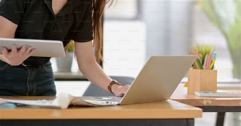 작업대에 서서 태블릿 노트북 및 디자이너 용품으로 작업하는 여성 디자이너의 크롭 샷 사진 Unsplash의 태국 이미지