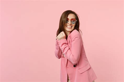 심장 안경 서에서 꽤 아름 다운 젊은 여자 미소의 초상화 스튜디오에서 파스텔 핑크 배경 옆에 고립 된 찾고 사람들은 진심으로 감정 라이프 스타일 개념입니다 복사 공간을 모의