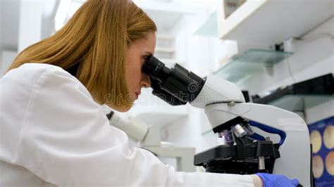 Female Scientist Looking Through Microscope In A Biochemical Laboratory Stock Footage Video