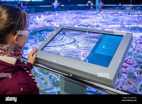 Woman Using Interactive Touchscreen Display At Modern Museum Or