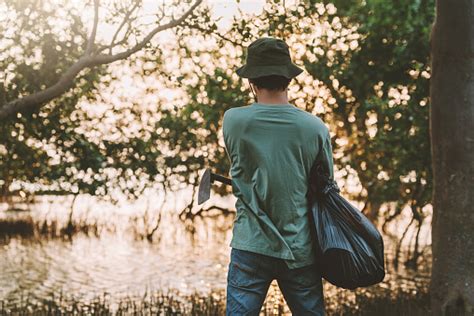 아시아 남자 환경 보전 자원 봉사자는 공공 공원 지역의 쓰레기 봉투에 플라스틱과 거품 쓰레기를 집어 든다 Vvolunteering Save World Concept 35