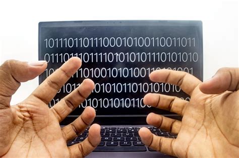 바이너리 코드로 가득 찬 노트북 화면에 손을 뻗고 있는 한 쌍의 손은 인간의 컴퓨터 상호 작용을 상징합니다 기술 프로그래밍 또는 데이터 개념에 적합 그래픽 사용자