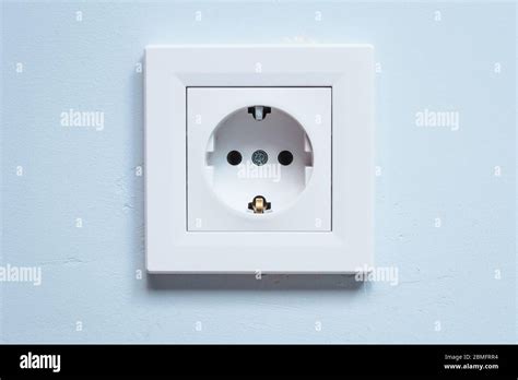 White Socket With Grounding Contacts On A Blue Wall Background Electricity Consumption Concept