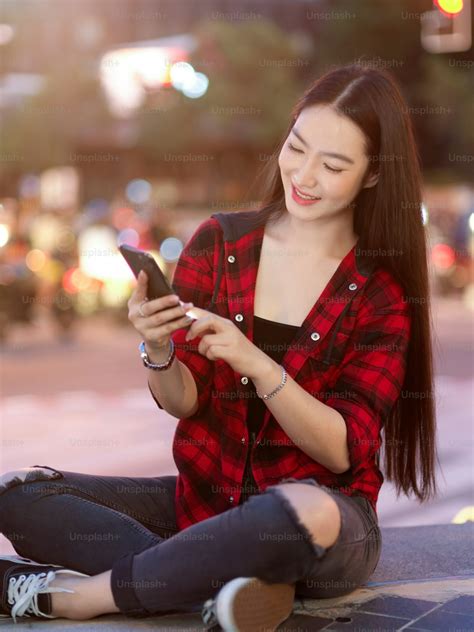 매력적인 여성 앉아 있고 밤에 흐릿한 도보 거리에서 휴대 전화를 들고 손 스마트폰에 힙스터 여자 문자 메시지 사진 Unsplash의 앉아 이미지