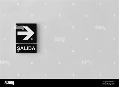 A Grayscale Shot Of An Exit SALIDA Sign In Spanish With Right Arrow Stock Photo Alamy