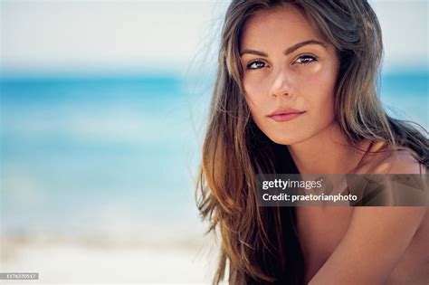 Portrait Of Young Girl Standing On The Beach And Enjoying The Ocean