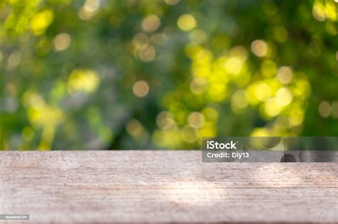 오래된 나무 테이블 상단의 빈 소박한 나무 질감 초점이 흐려진 햇빛 흐릿한 단풍 뒤뜰 배경이 있는 녹색 공원에 대해 흐릿합니다 모형 표시 제품 몽타주 주요 시각적 레이아웃