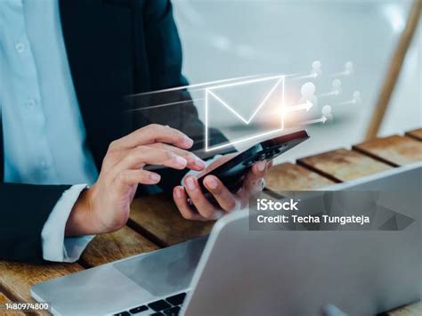 이메일 보내기 메시지 보내기 및 비즈니스 팀워크 개념 비즈니스 사람이 전화를 사용하고 랩톱 컴퓨터로 작업하는 동안 많은 사람 아이콘이 나타나는 디지털 문자 기호의 빠른 이동