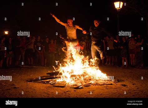 Two Men Jumping Together Over A Bonfire During Saint Johns Eve In